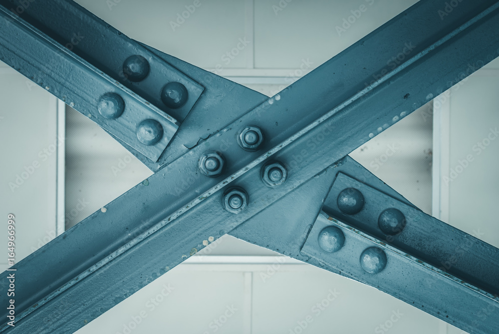 Blue construction beam forming an X. Halogen light background ...