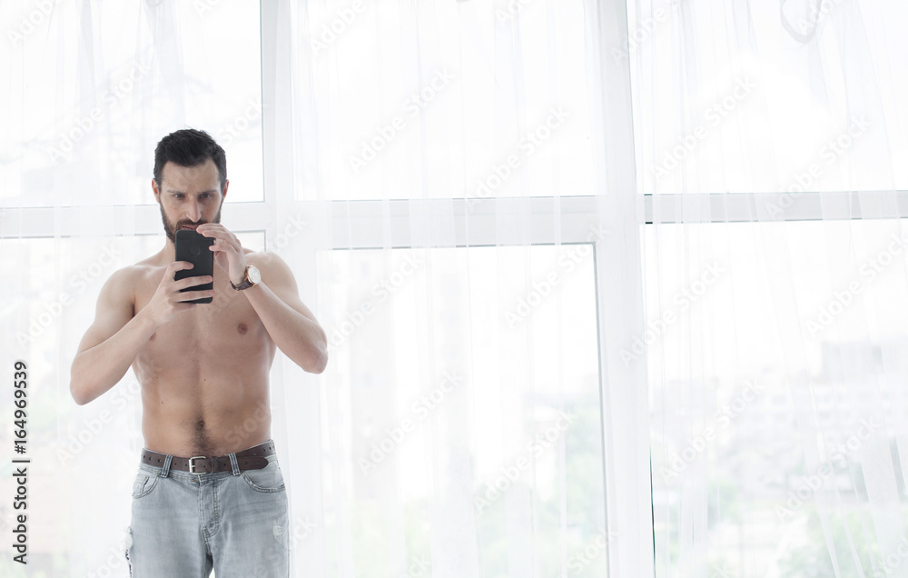 Handsome shirtless muscular bodybuilder man in jeans taking selfie with ...
