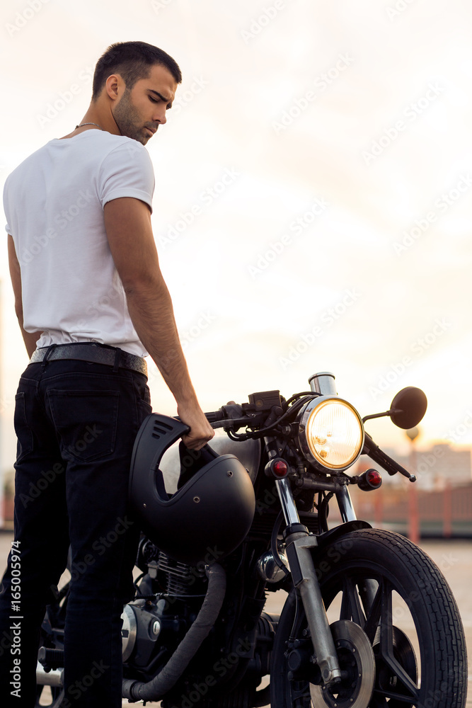 Sporty biker handsome rider male in white blank t-shirt walk to classic ...