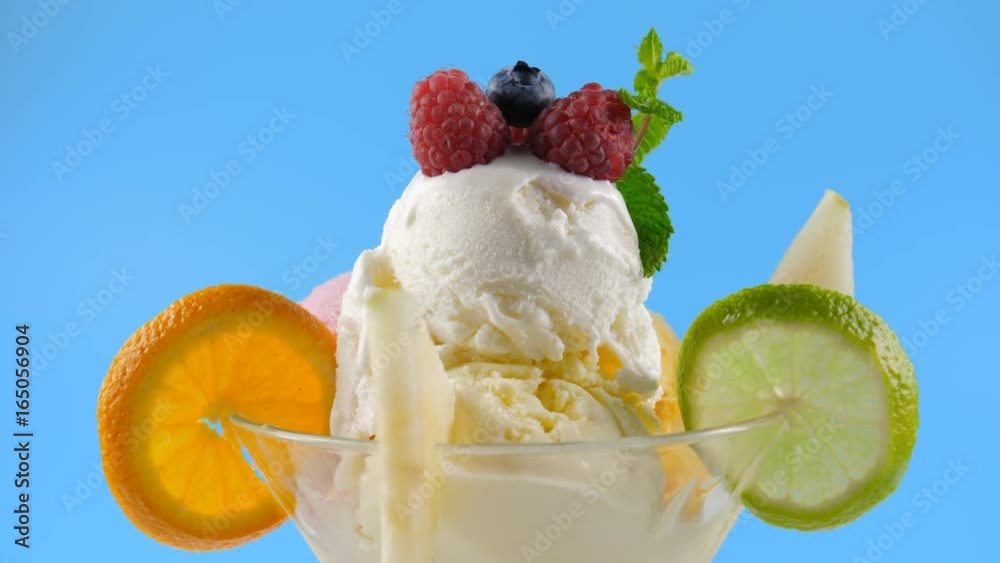 Mixed ice cream in sundae glass cup with slices of fruits and berries ...