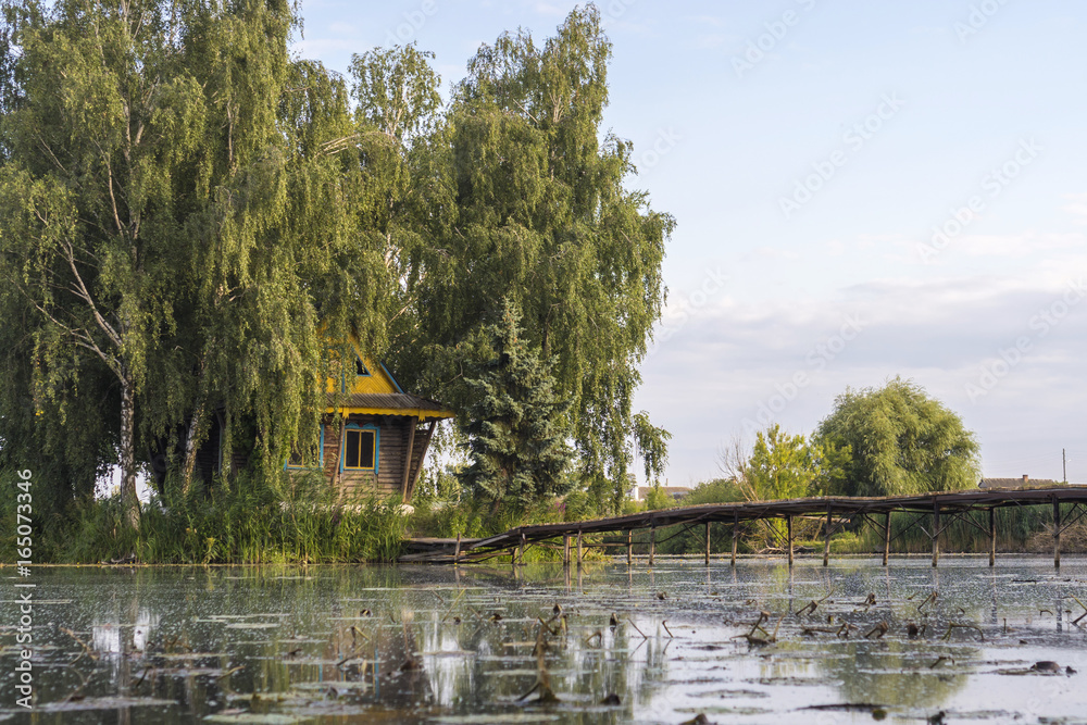 Foto de A natural landscape with bridge to the house on lake. A wooden ...