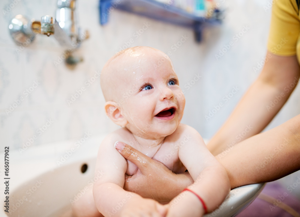 Happy laughing baby taking a bath. Little child in a bathtub. Smiling ...