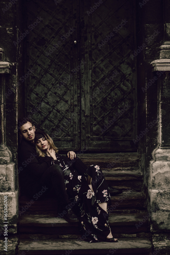 stylish gypsy couple in love embracing in evening city street at old ...