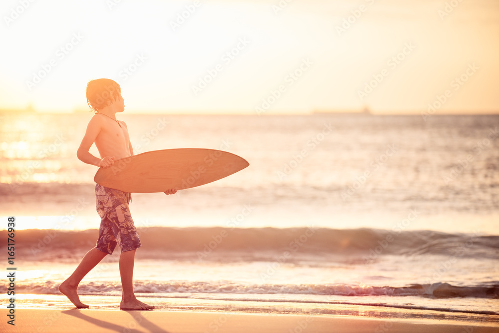 Boy skim boarding at the beach on a late summer afternoon Stock Photo ...