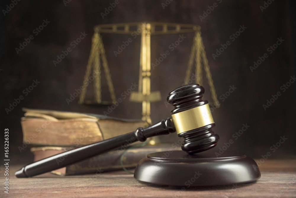Judge gavel, old books and scales on a wooden table, justice symbols for balance and power in ...