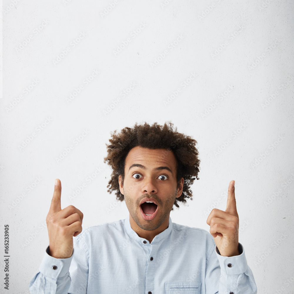 Vertical portrait of Afro American bug-eyed male being shocked from ...