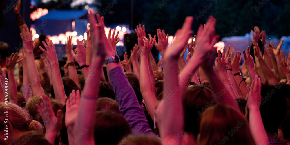 At the concert the crowd supports the musicians by raising their hands ...