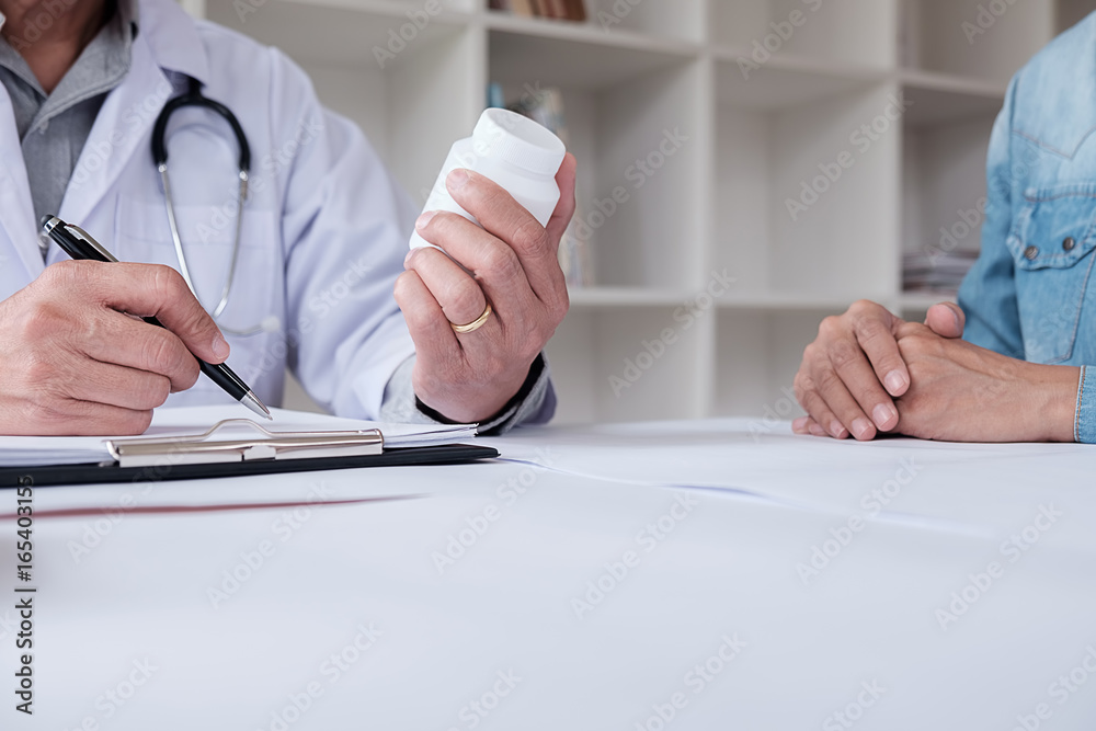 Patient listening intently to a male doctor explaining patient symptoms ...