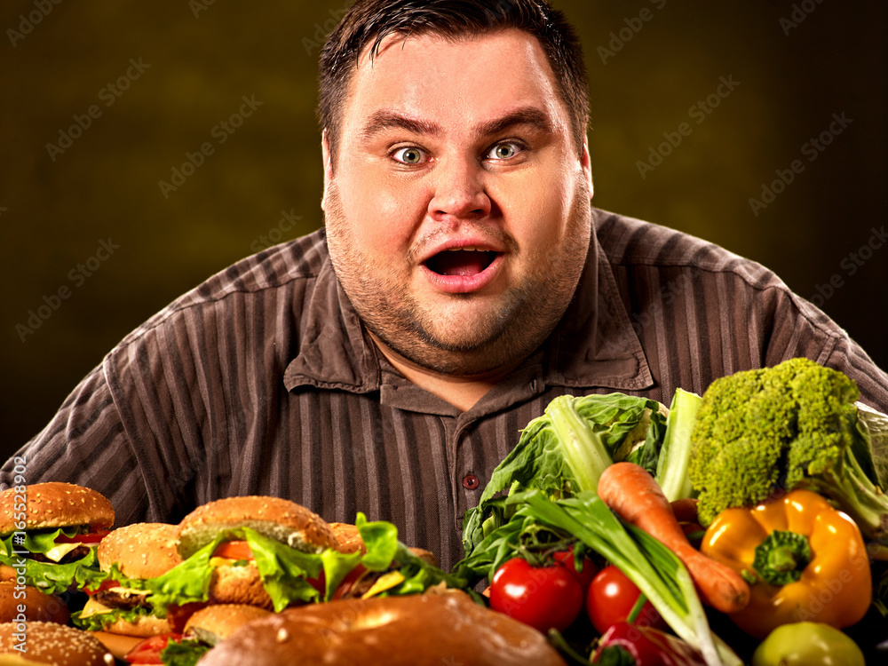 Foto de Fat man who makes choice between healthy and unhealthy food ...