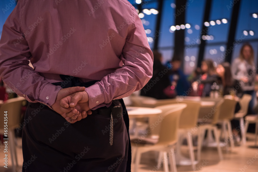 waiter standing with hands behind his back Stock Photo | Adobe Stock