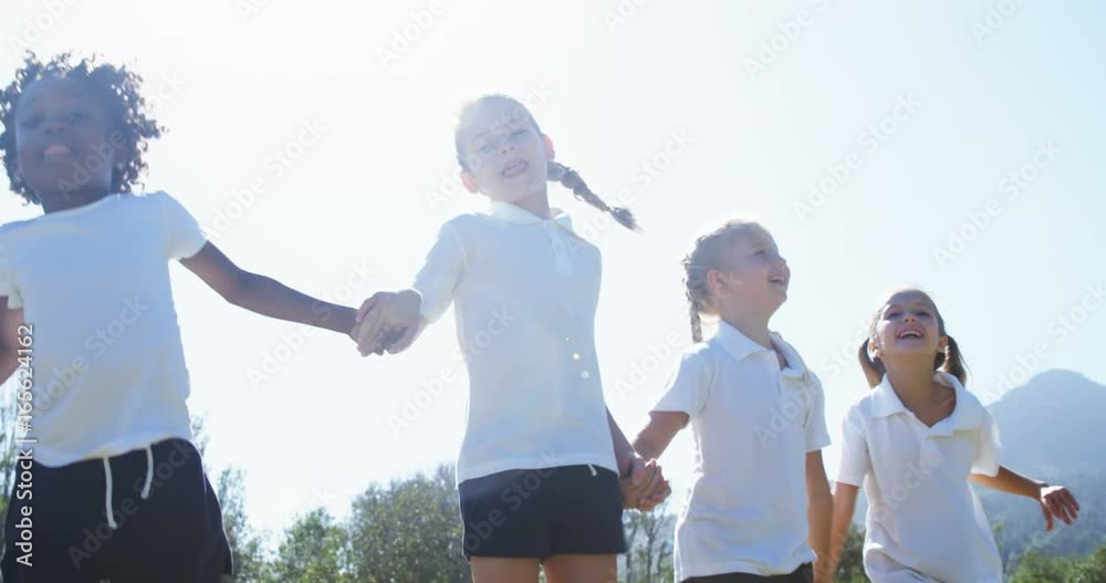 School kids holding hands and jumping in park Stock Video | Adobe Stock