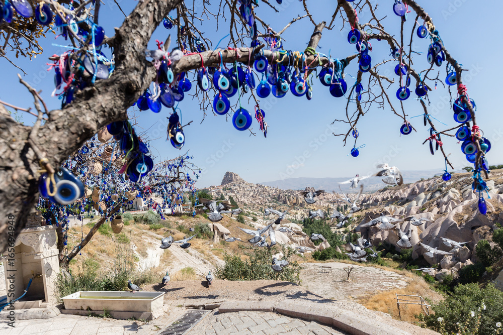 Evil Eye Beads on Tree and Fairy tale chimneys on background of blue ...