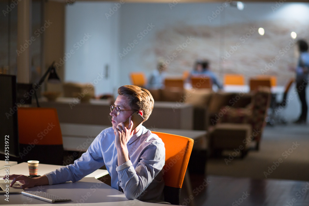 man using mobile phone in dark office Stock Photo | Adobe Stock