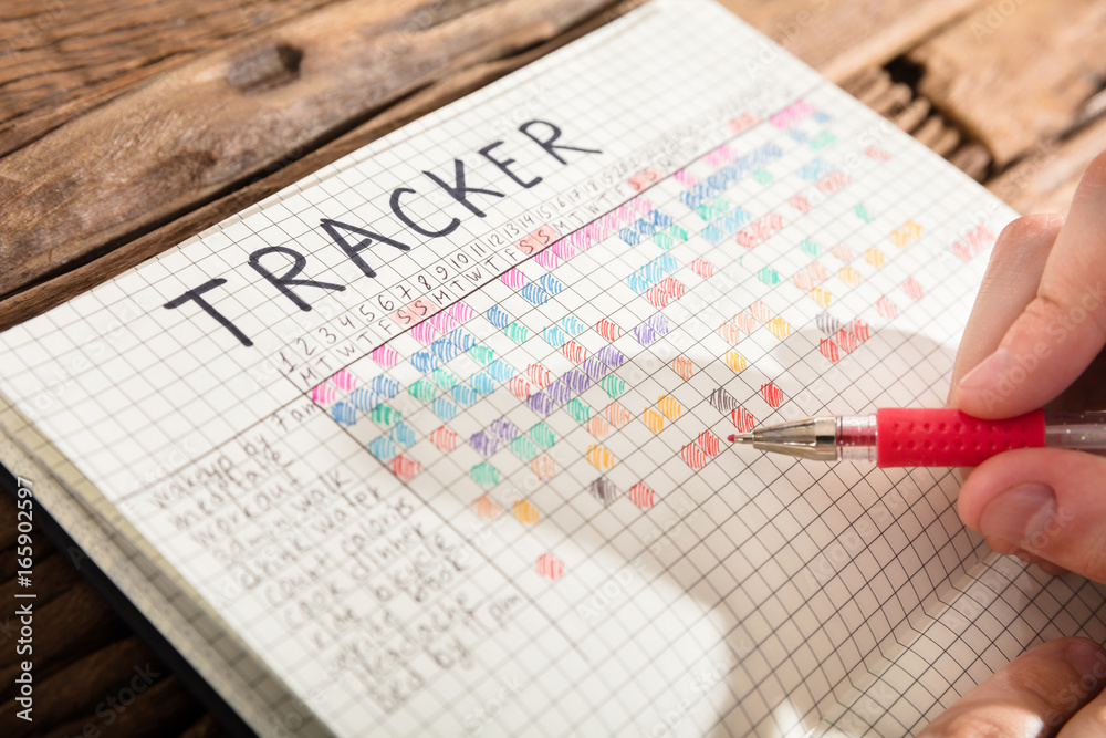 Person Drawing Tracker Chart On Notebook Stock Photo | Adobe Stock
