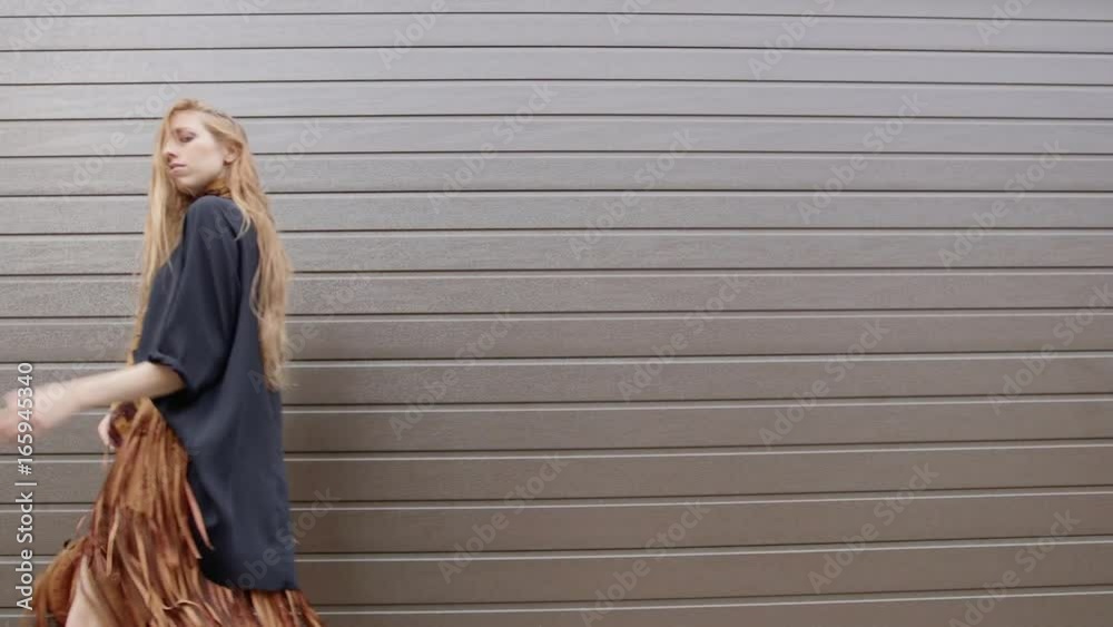Young woman smiles and looks at the camera, posing and showing dress ...