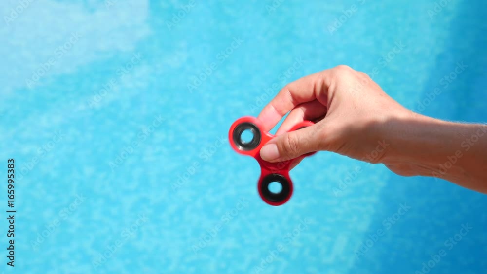 Vidéo Stock Red hand spinner or spinner, rotating on the person's arm ...