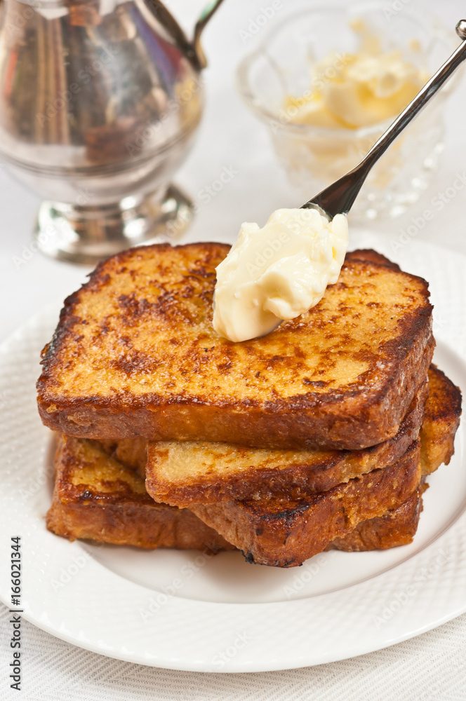 Stack of baked french toast with a artisan spreading knife with butter ...