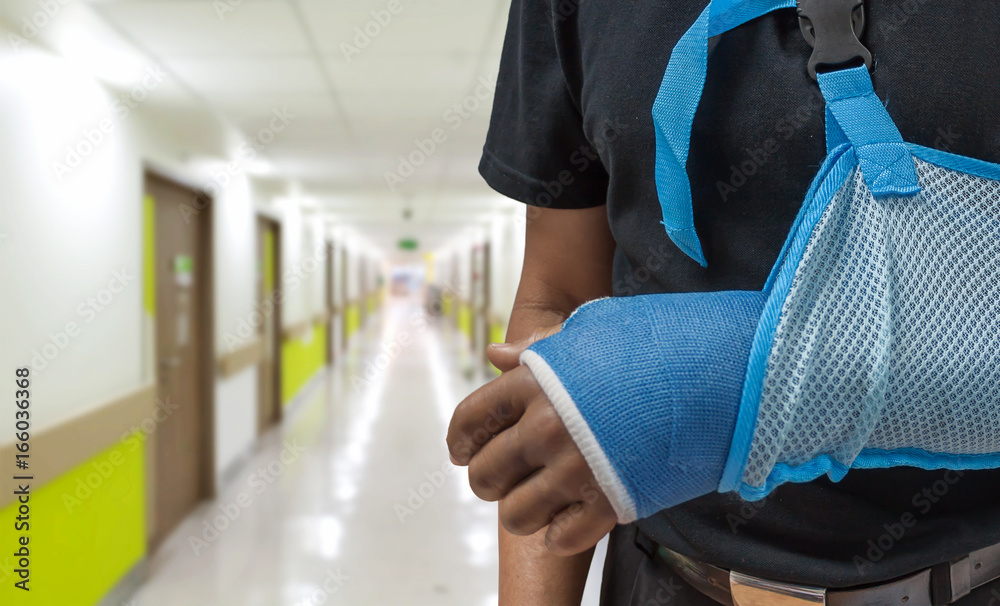 Man's arm in cast and sling with blurred hospital background Stock 사진 ...