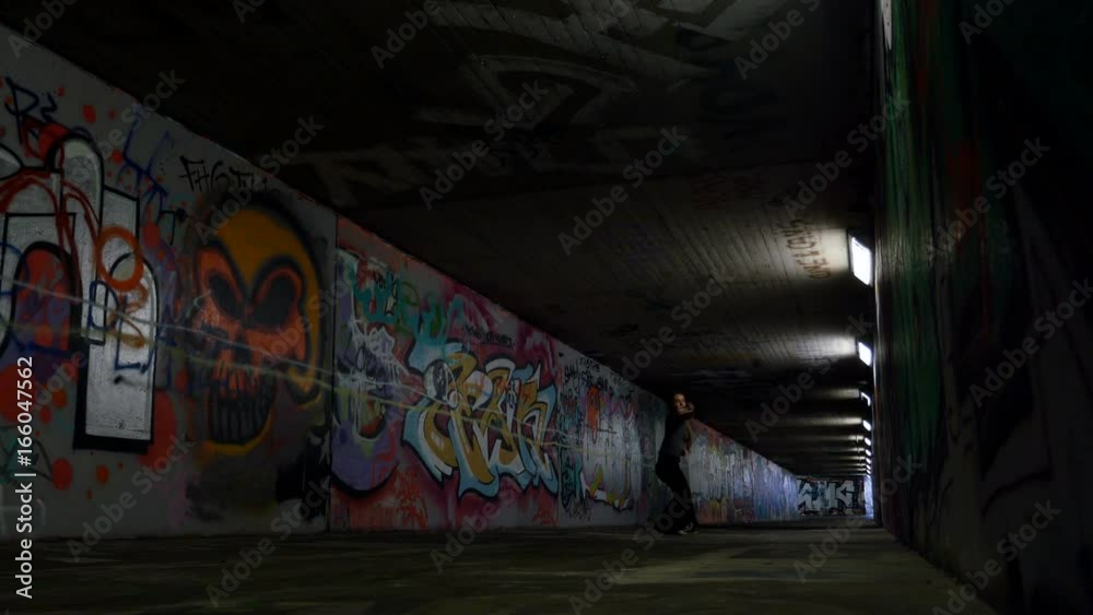A young woman performs a modern dance in an underpass. The underground ...