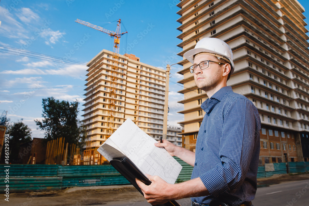 Close-up man builder European wearing helmet, glasses, shirt in his ...