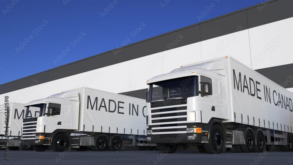 Freight semi trucks with MADE IN CANADA caption on the trailer loading ...