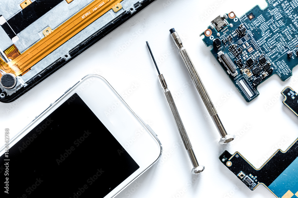 Parts of disassembled cell phone and screwdrivers on white background ...