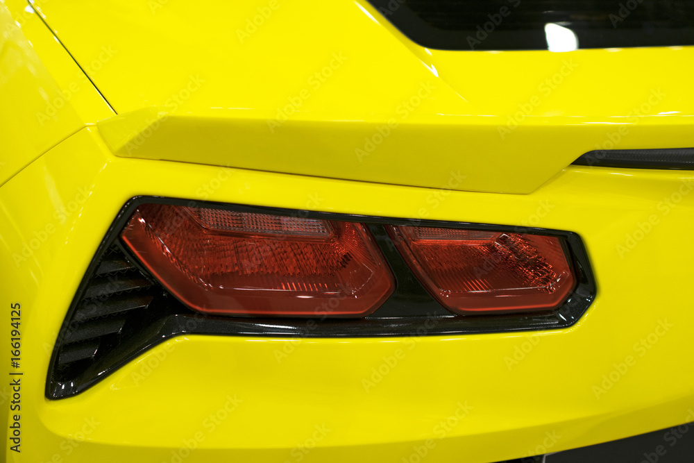 Red Rear light on a modern yellow sport car with reflection. The ...