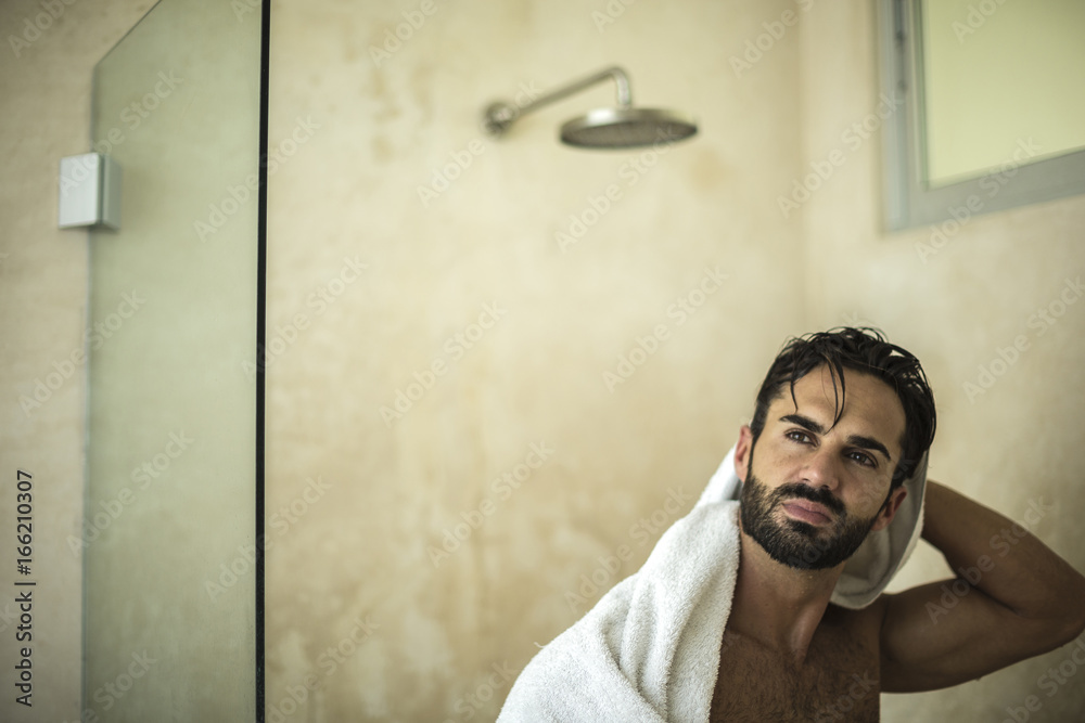 Man standing in bathroom, drying himself with towel Stock Photo | Adobe ...