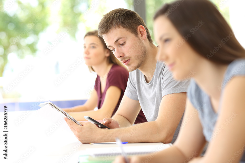 Student distracted with a phone during a class Stock Photo | Adobe Stock
