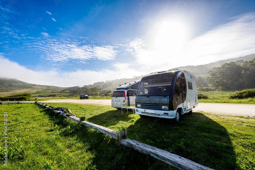 Motorhome RV and campervan are parked on a beach. Stock Photo | Adobe Stock