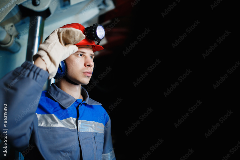 miner man stands in a helmet in the mine against the background of a ...