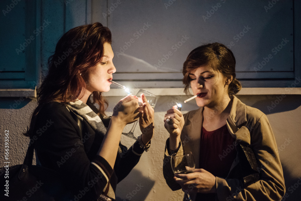 Women lighting up a cigarette Stock Photo | Adobe Stock