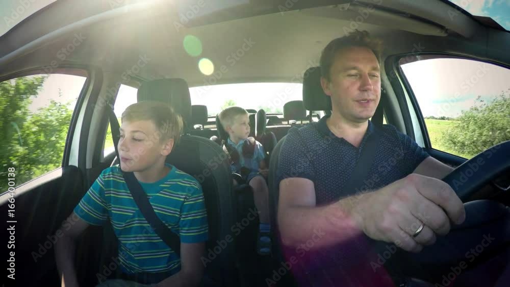 Children boys brothers riding in the car with father male in vehicle ...
