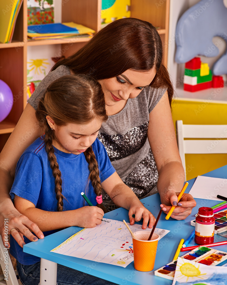Small students girl with teacher painting in art school class. Child ...