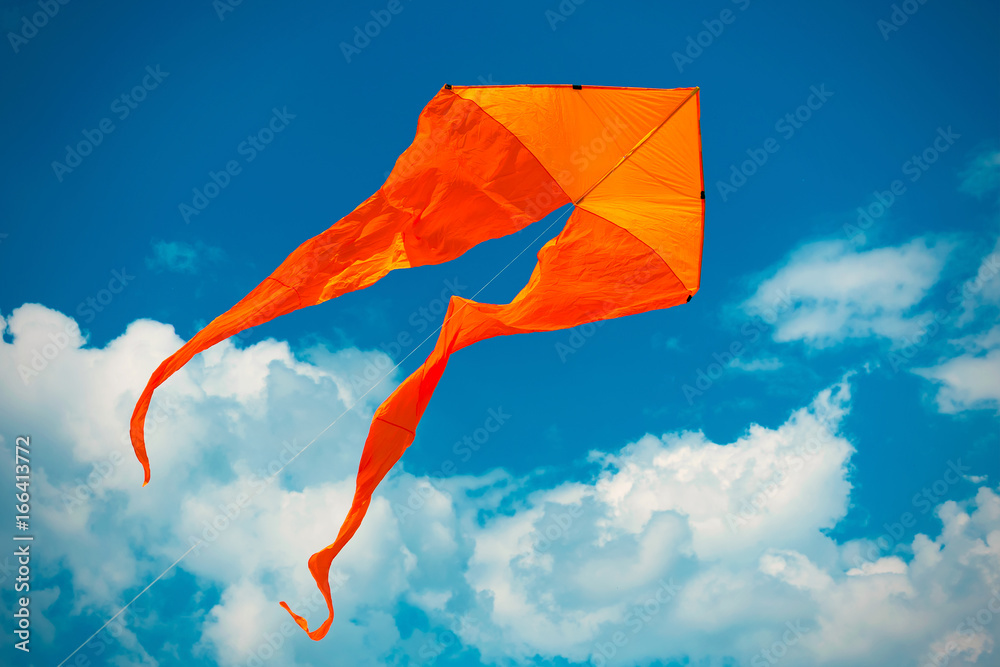 Orange kite in the blue sky with white clouds Stock Photo | Adobe Stock