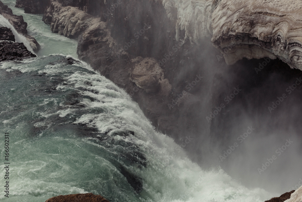water rushing over an icy waterfall and falling into a gorge Stock ...