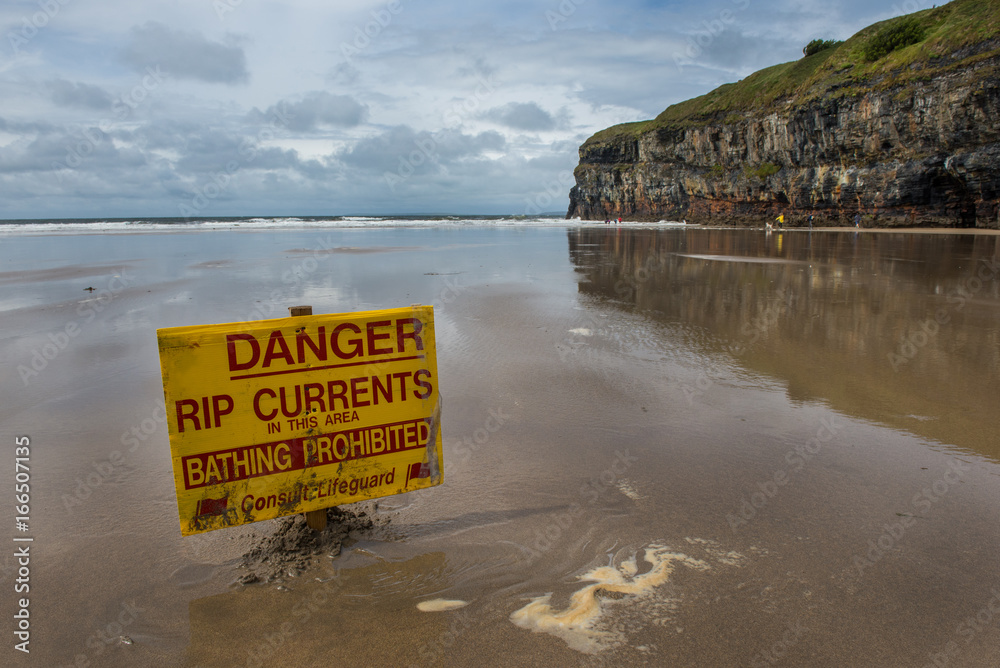 Riptide currents warning sign for swimmers at the beach on a stormy day ...