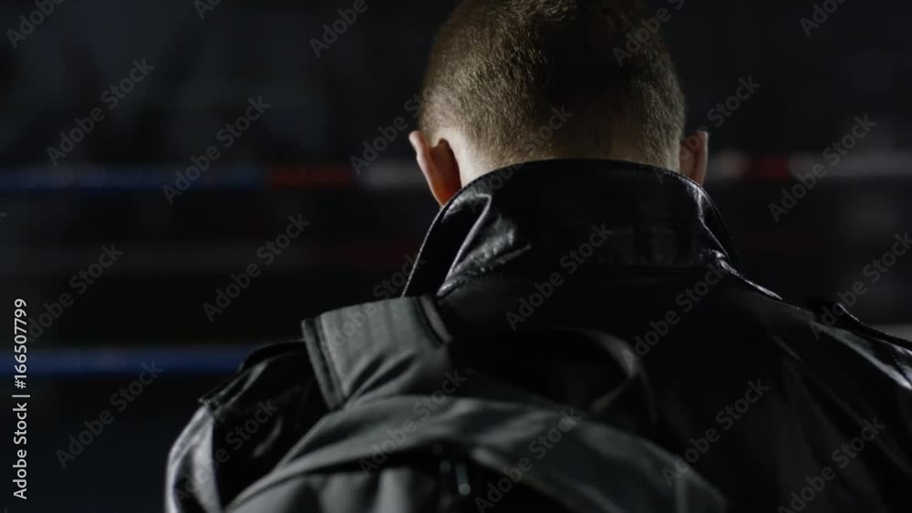 Back view of traveling handsome man in jacket with suitcas looking up ...