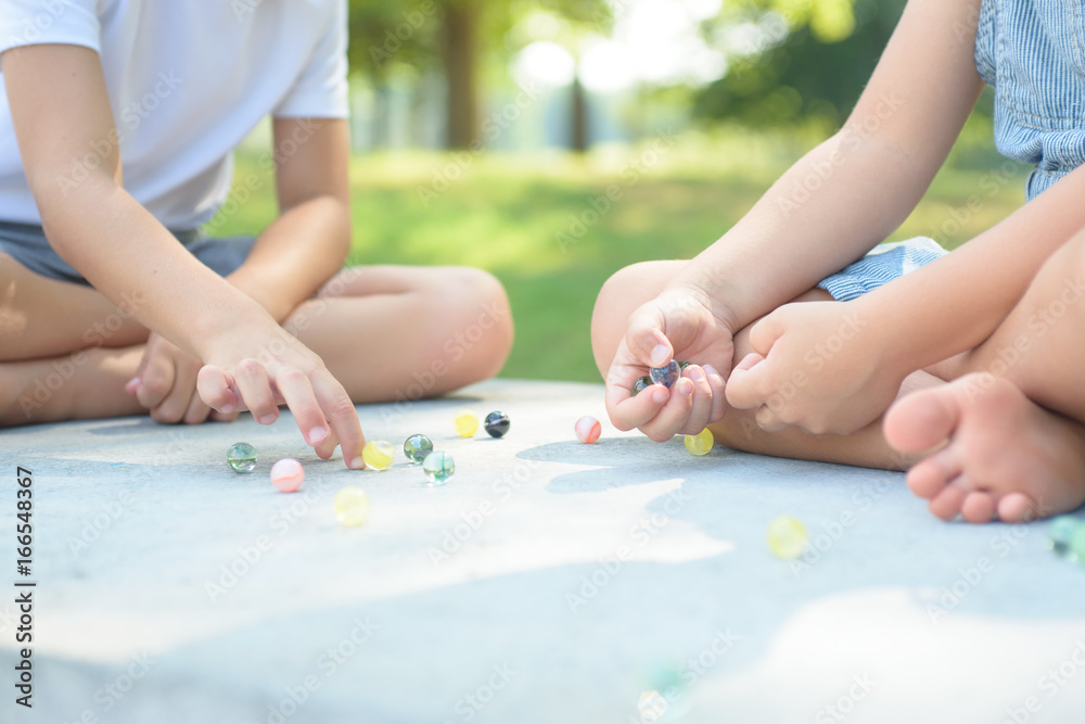 Kids playing marbles game outside Stock Photo | Adobe Stock