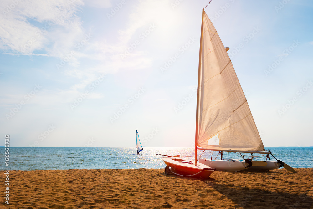 Sailboat on beach and sky background with windsurfing in the wind ...