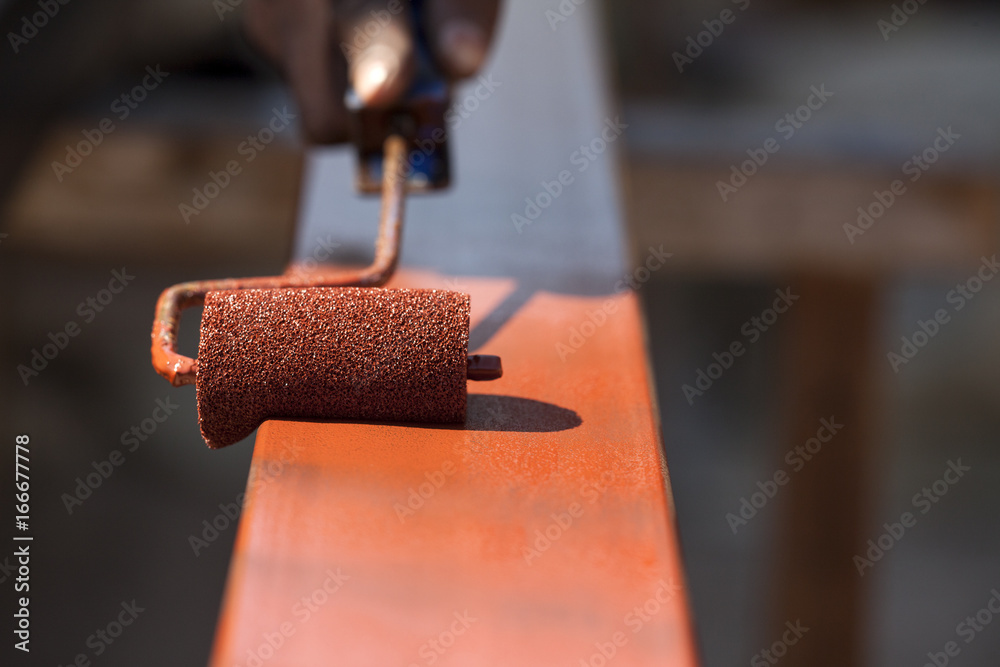 Painting of metal pipe using a roller with the basic paint Stock Photo ...