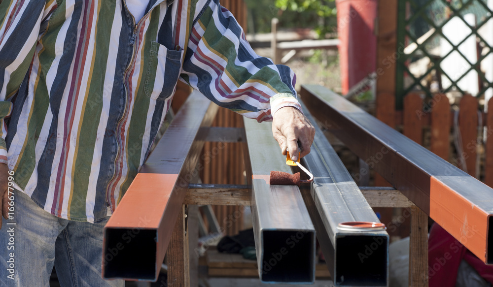 Painting of metal pipe using a roller with the basic paint Stock Photo ...
