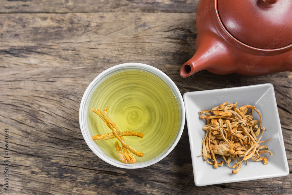 cup of cordyceps (chong cao) tea on old and crack wooden surface with ...
