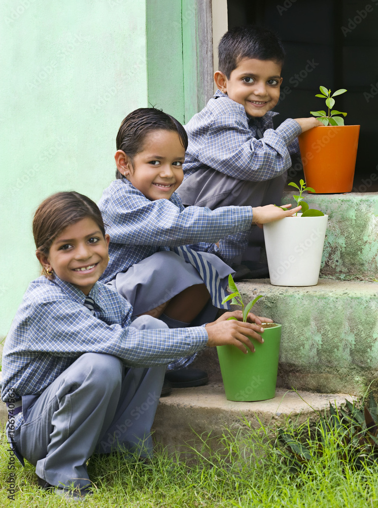 School kids with colored potted plants Stock Photo | Adobe Stock