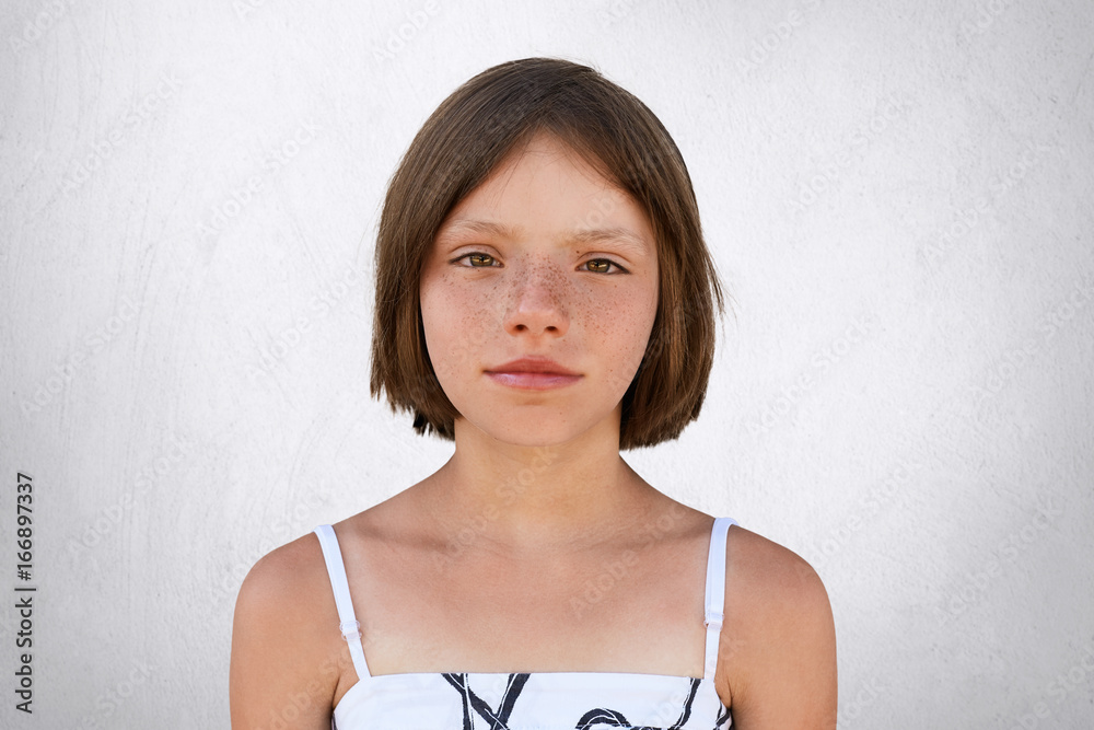 Cute little girl with short dark bobbed hair, brown wide shining eyes ...