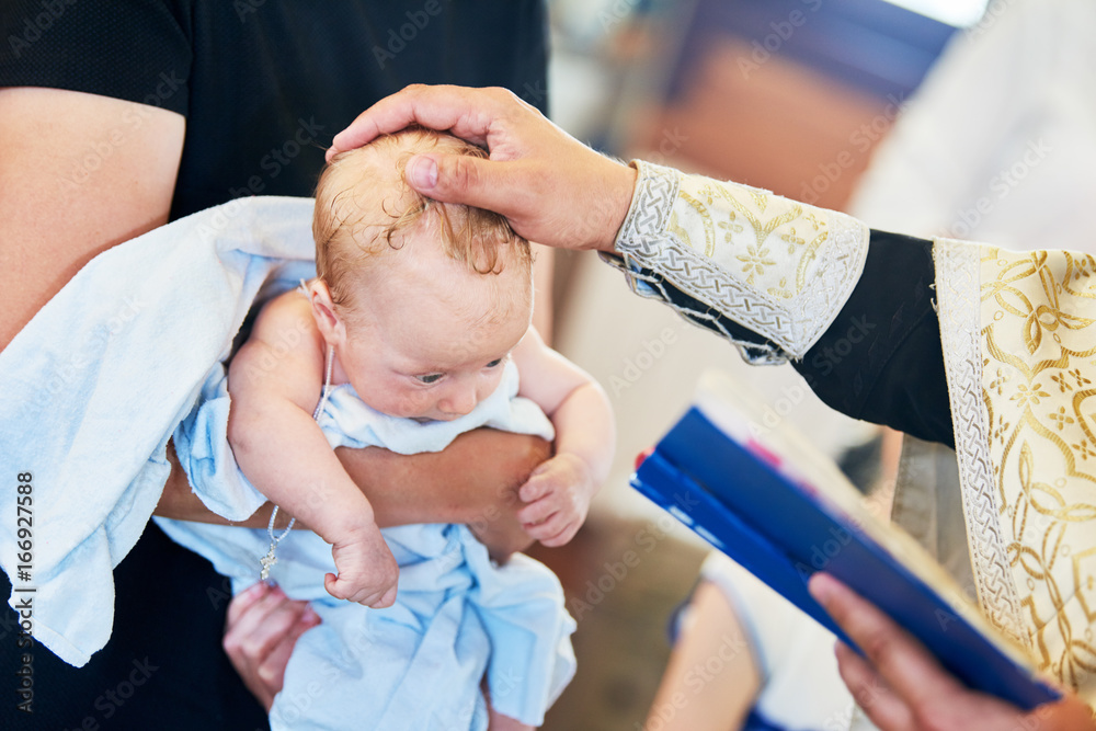 The sacrament of baptism. Newborn baby during christening and ...