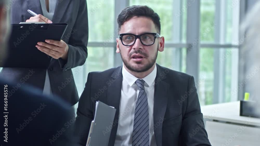 Zoom in of angry businessman in suit and glasses hitting desk with ...