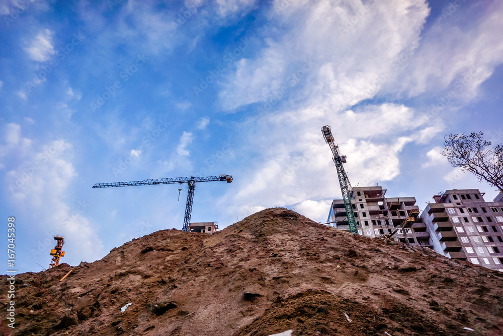 Building crane at the background of a multi-storey building under ...