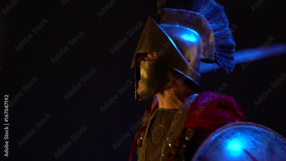 Roman Legionnaire in helmet and armor, falls into a rage, shields ...