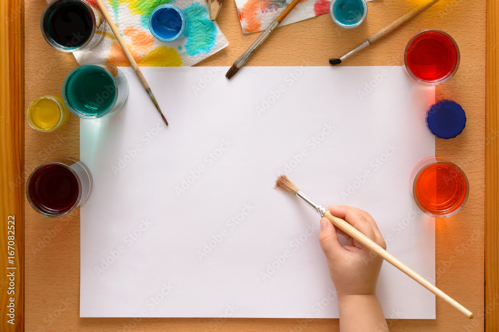Preparing to drawing. Blank sheet among watercolors and brushes.Child's ...